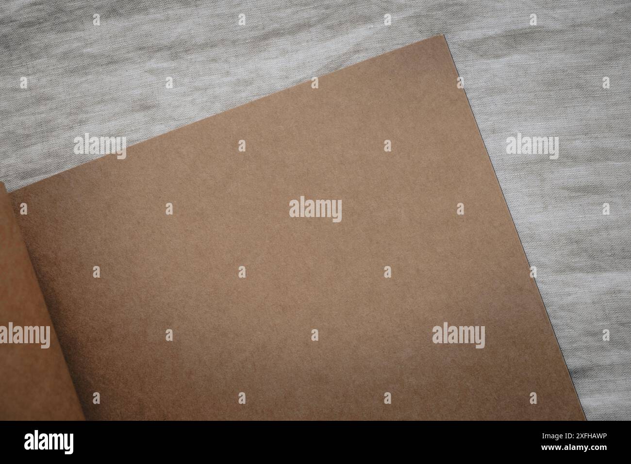 Top view to blank open brown notebook page on natural gray linen fabric ...