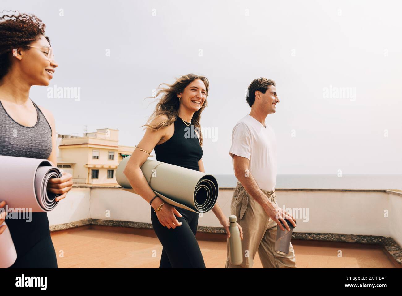 Smiling friends holding yoga mats hi-res stock photography and images ...