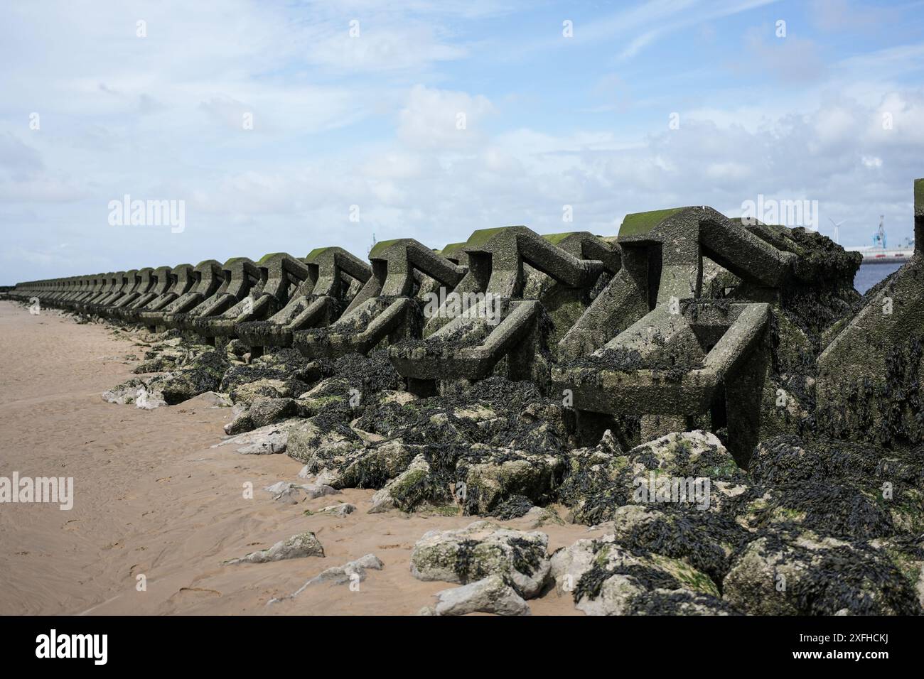 Low water exposes the Sea defences, showing a concrete pre-formed ...