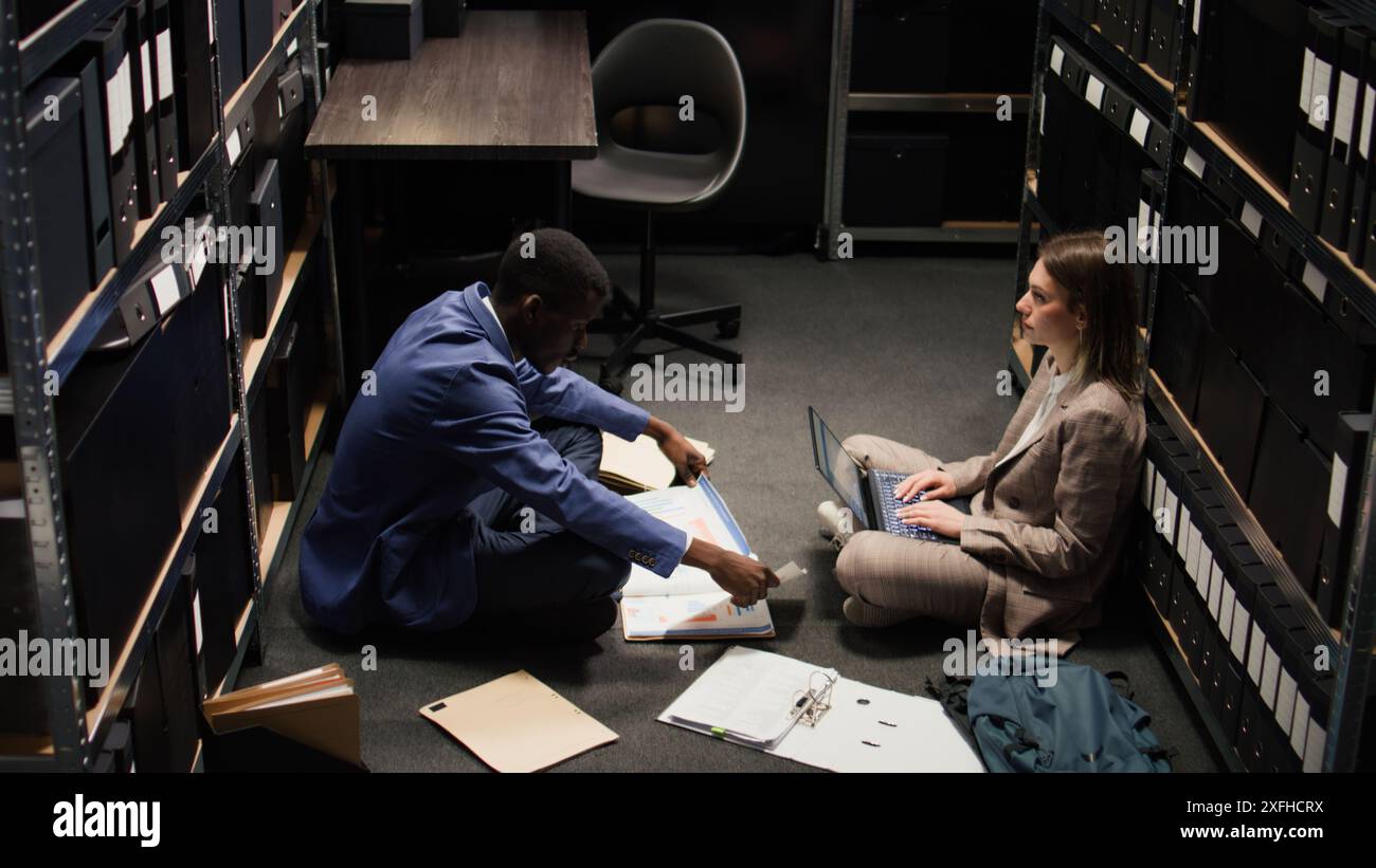 African american policeman reading criminal records files on office ...