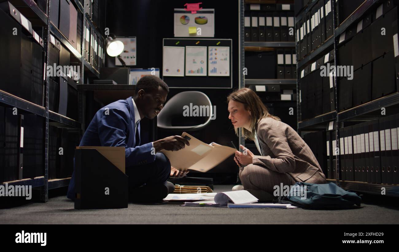 In office space, male private detective examines case files and reads ...