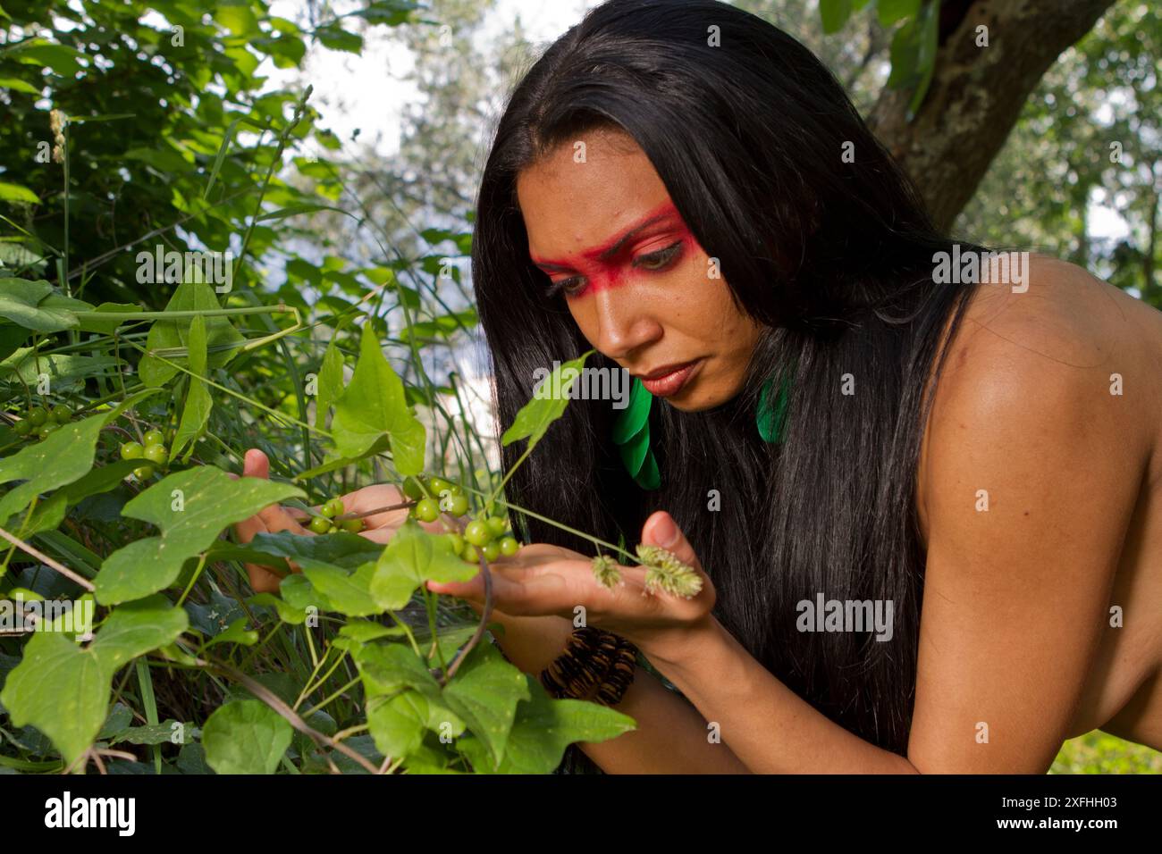 A young indigenous woman from a Brazilian tribe with painted face ...