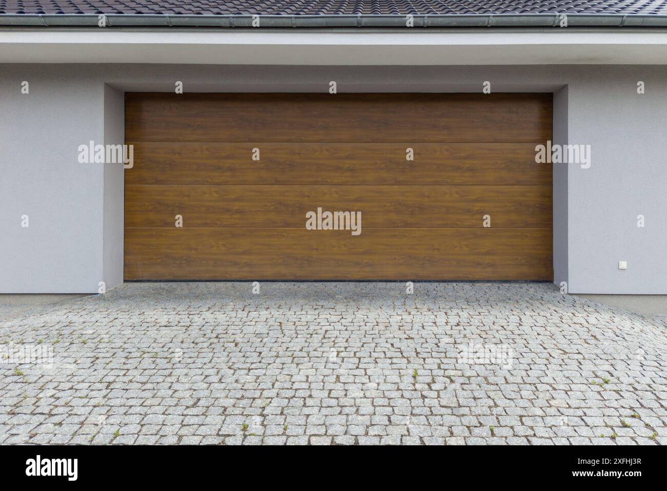 Modern Wooden Garage Door with Cobblestone Driveway Stock Photo - Alamy