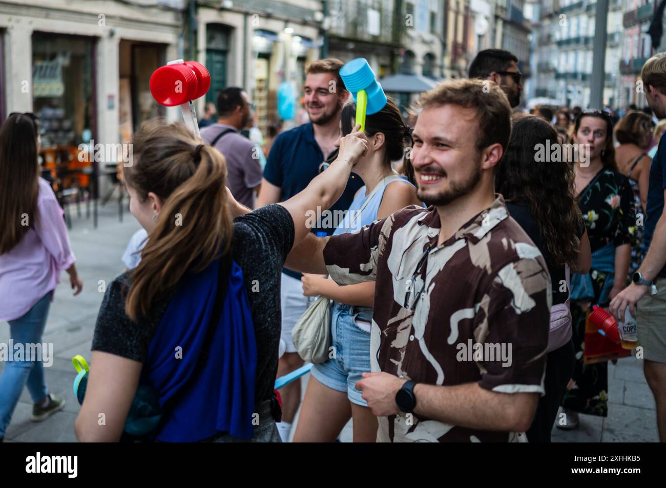 Greeting people with wilting leek and plastic hammers during Festival ...