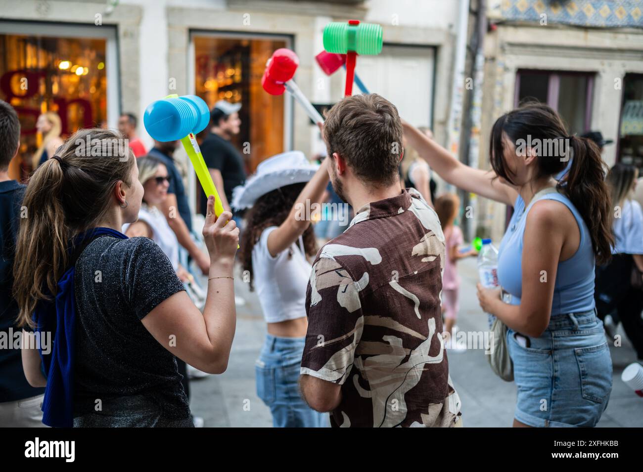 Greeting people with wilting leek and plastic hammers during Festival ...