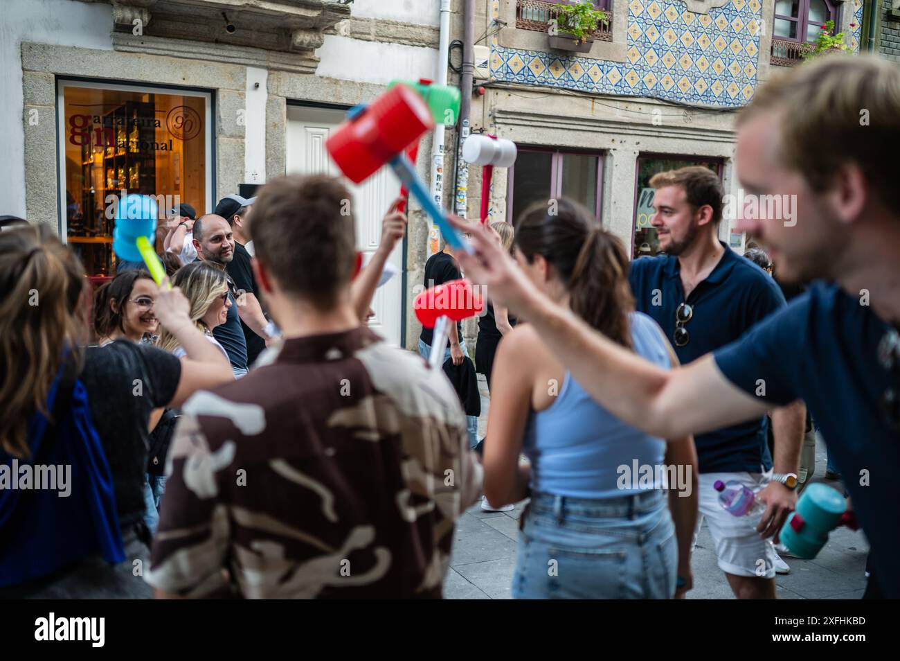 Greeting people with wilting leek and plastic hammers during Festival ...