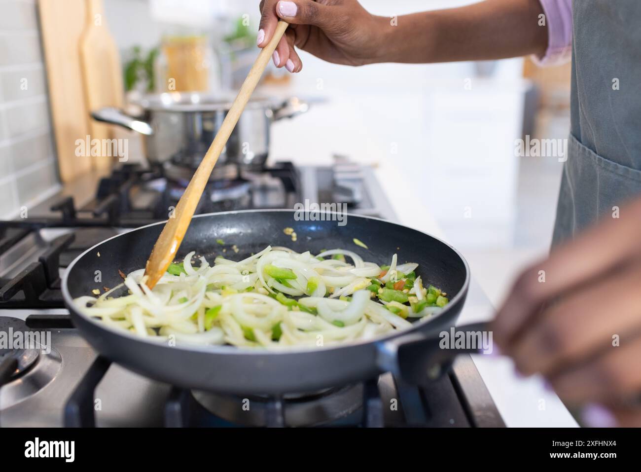Frying onions in pan person hi-res stock photography and images - Alamy
