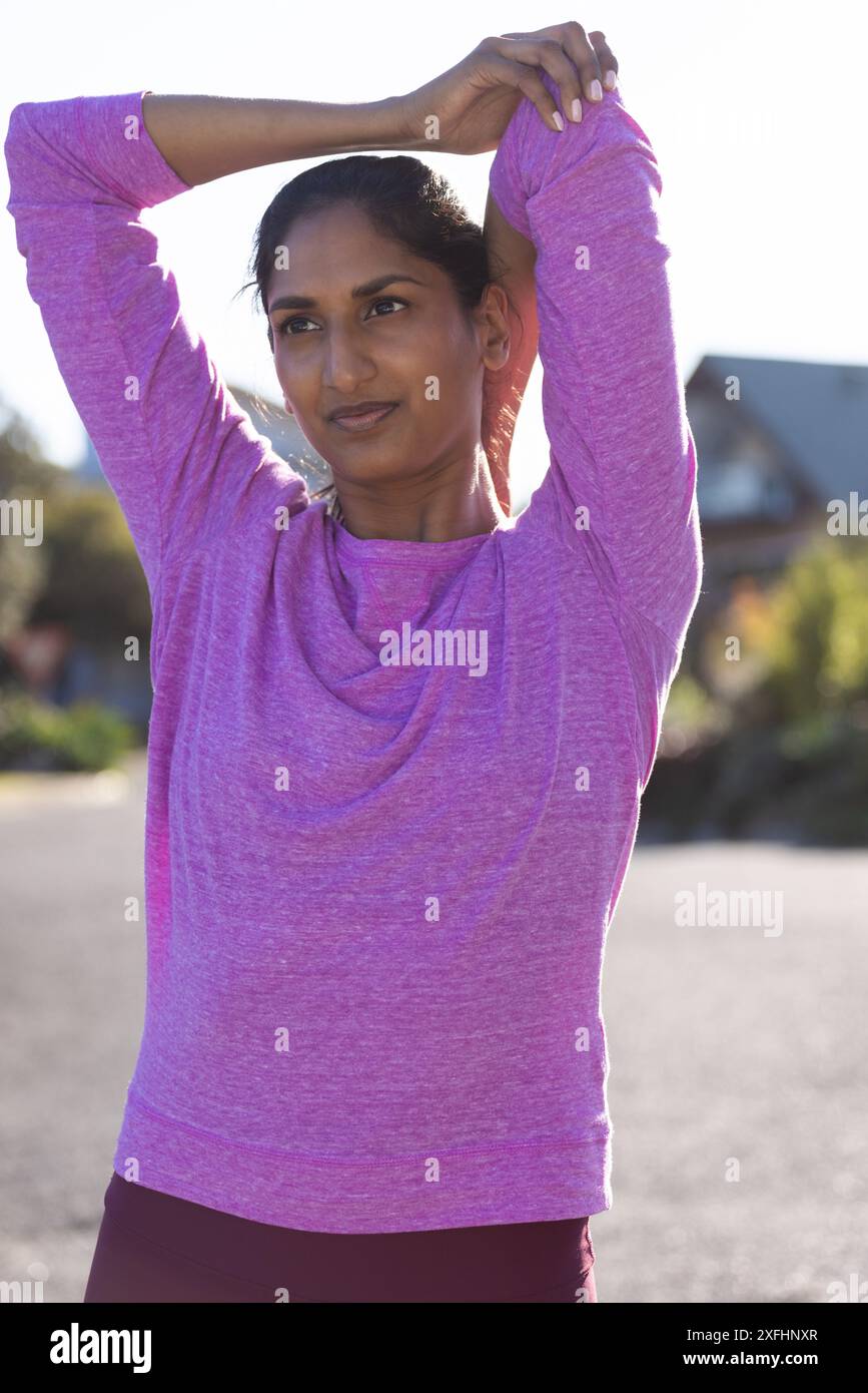 Stretching outdoors, woman in pink athletic wear enjoying morning ...