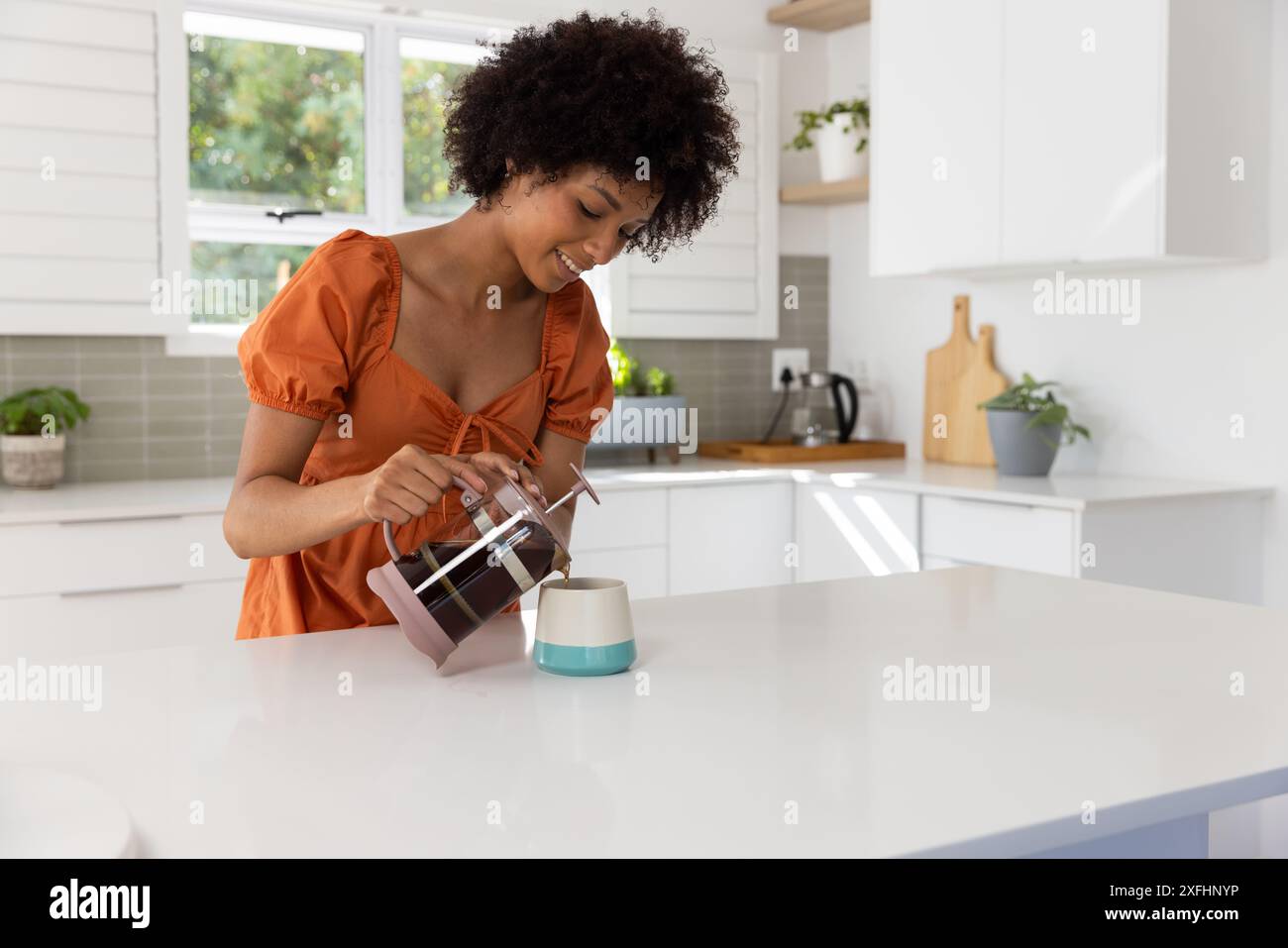 Pouring coffee from French press into cup, woman enjoying morning in ...