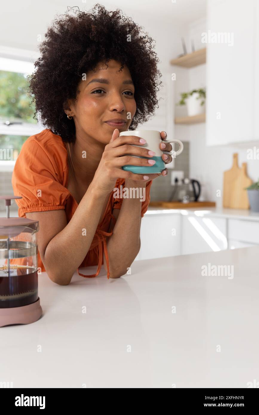 Drinking coffee, woman leaning on kitchen counter and enjoying morning ...