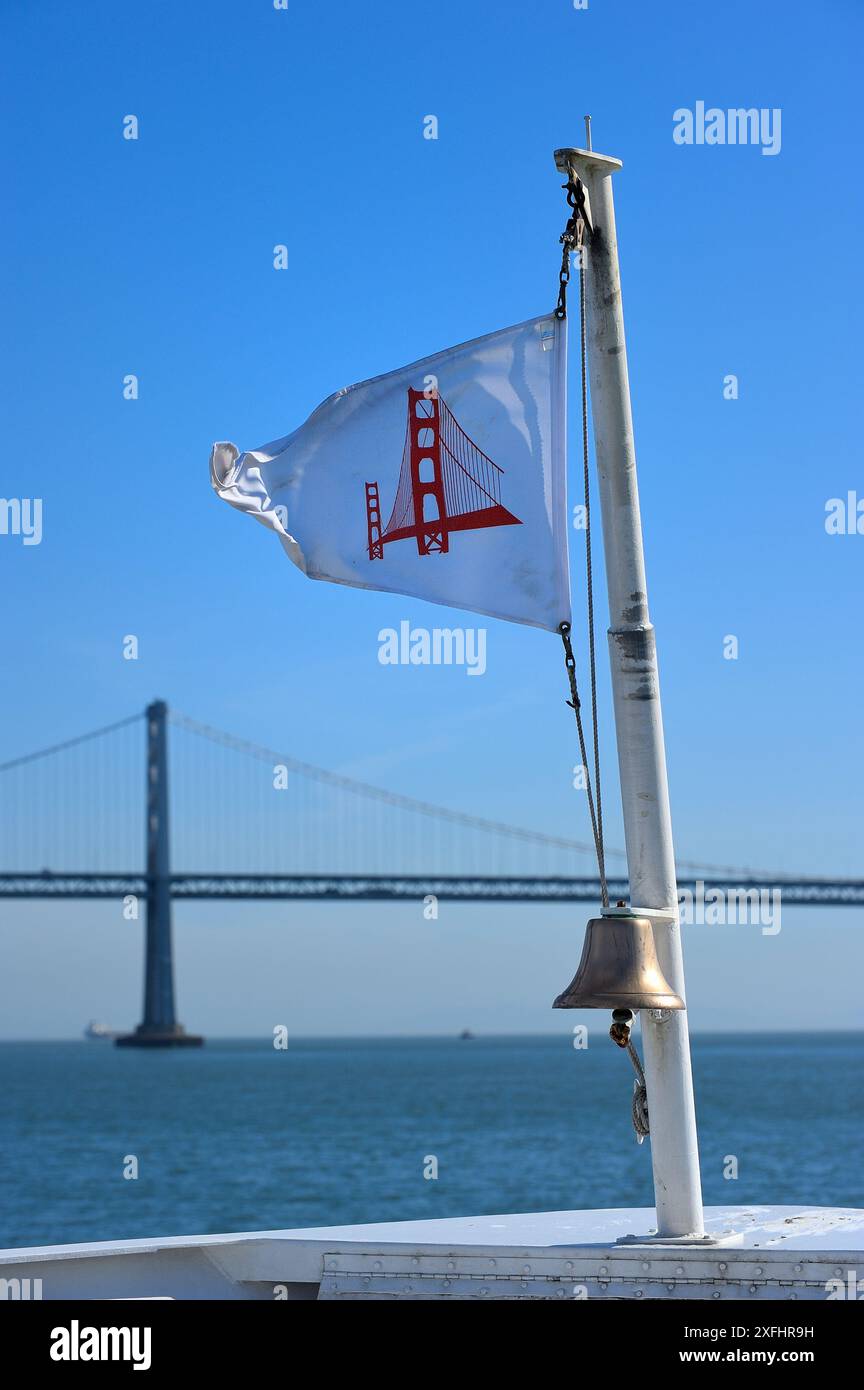 Two landmarks - a Golden Gate Bridge flag in front of the Bay Bridge ...