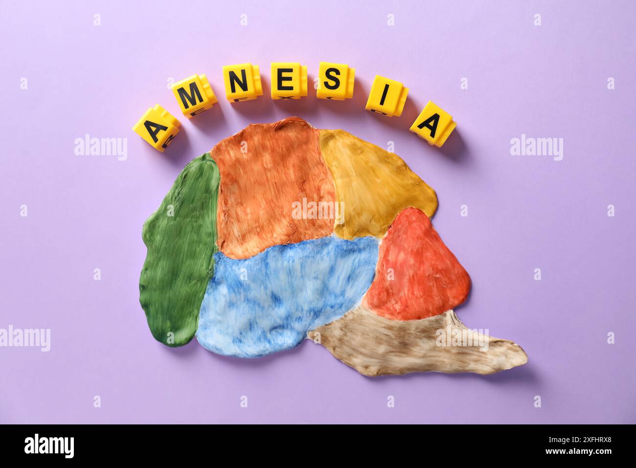 Word Amnesia made of yellow cubes and brain with sections on violet ...