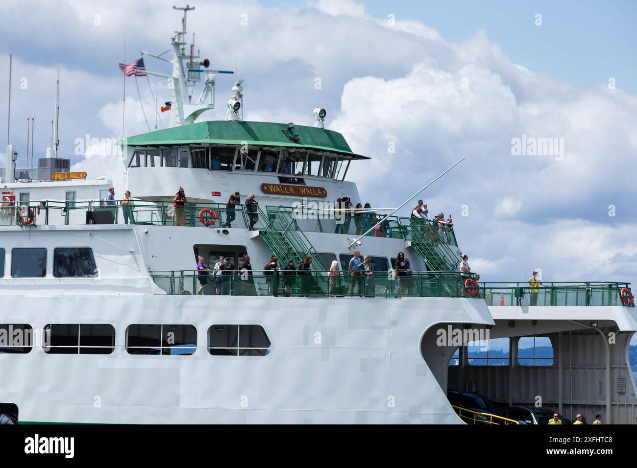 Passengers enjoy the view of the city as the M/V Walla Walla approaches ...