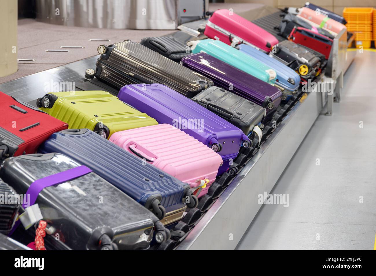 Bright suitcases on luggage conveyor belt at arrival area of passenger ...