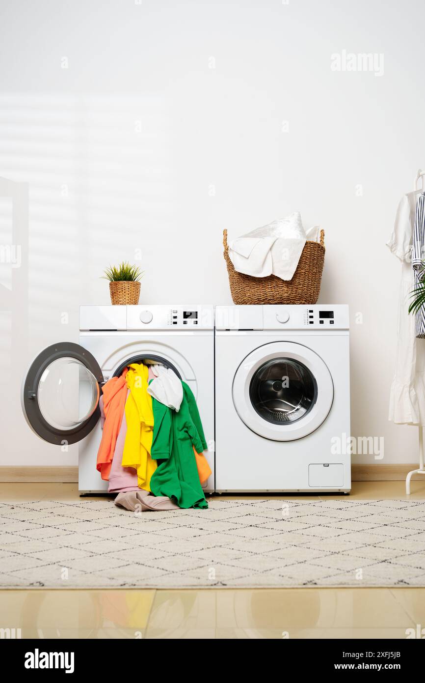 White Laundry Appliances With Colorful Clothes Overflowing From Washing ...