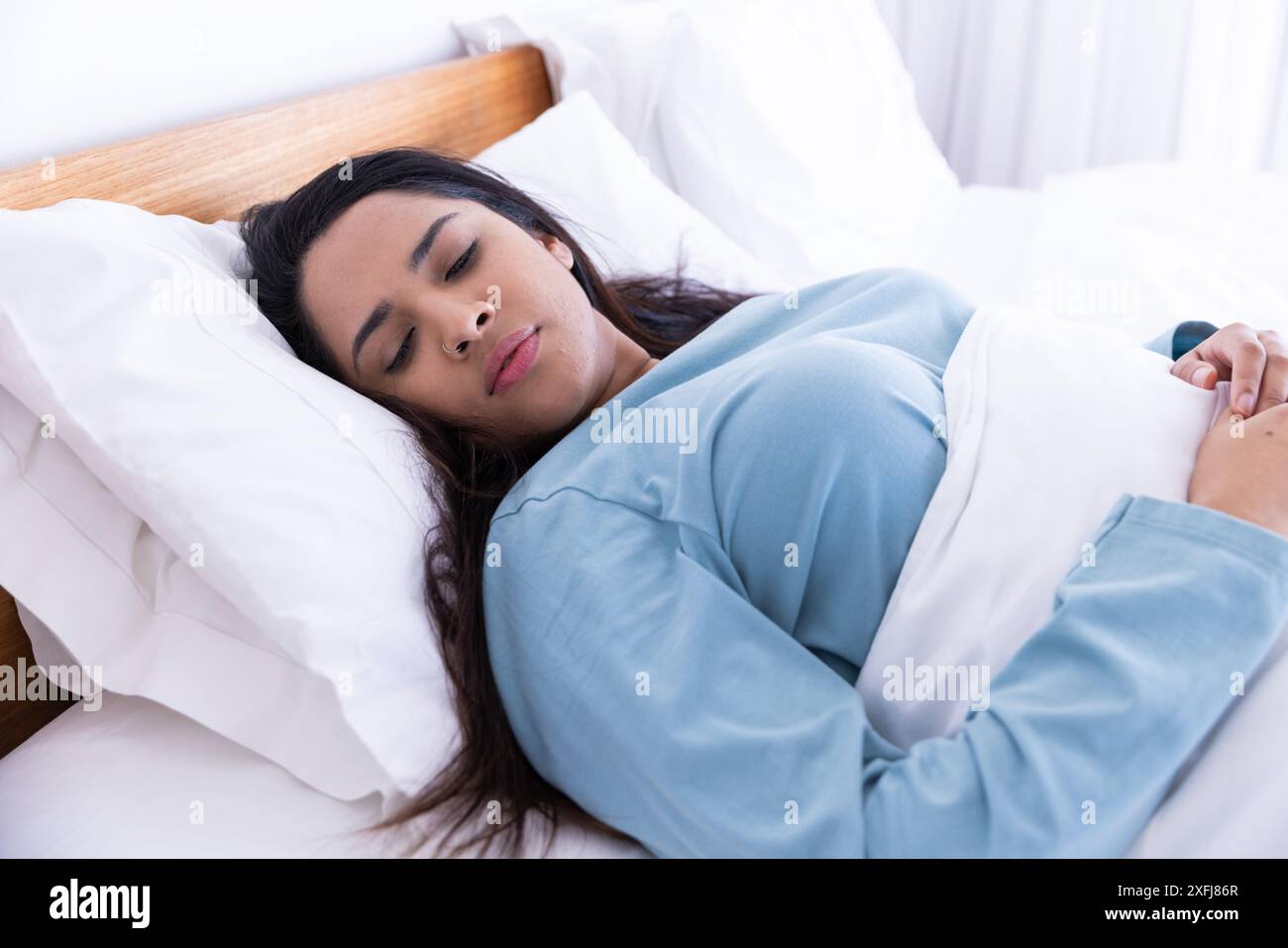 Sleeping peacefully under white blanket, woman resting in bed ...