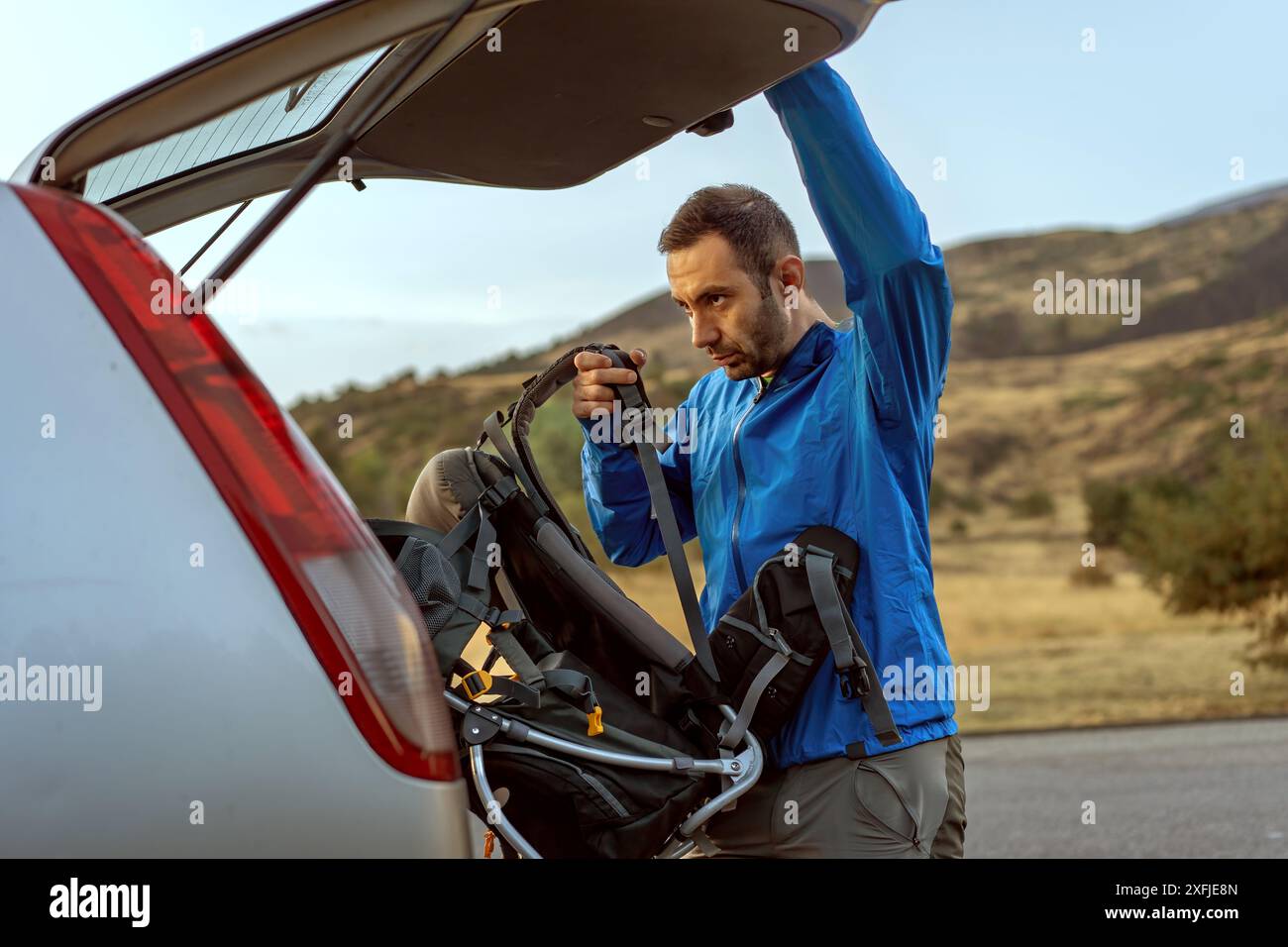 Father preparing for hike - loading child backpack carrier, outdoor ...