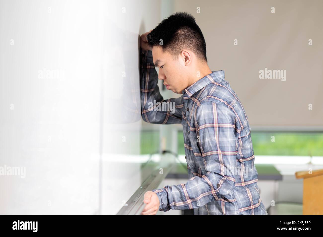 A young college student is tired and leaning on the classroom ...