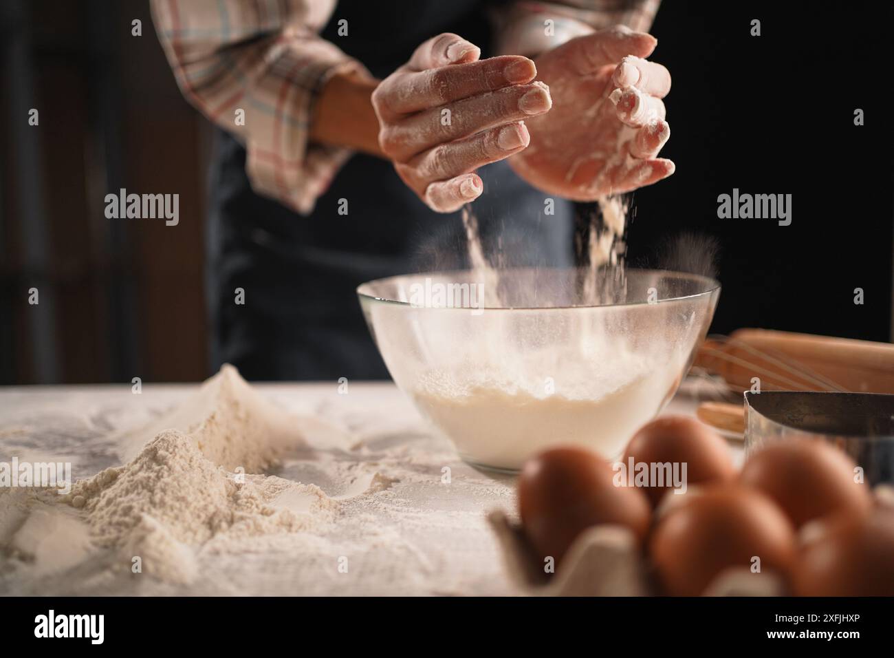 Close up woman hands pouring flour into bowl while baking at home ...