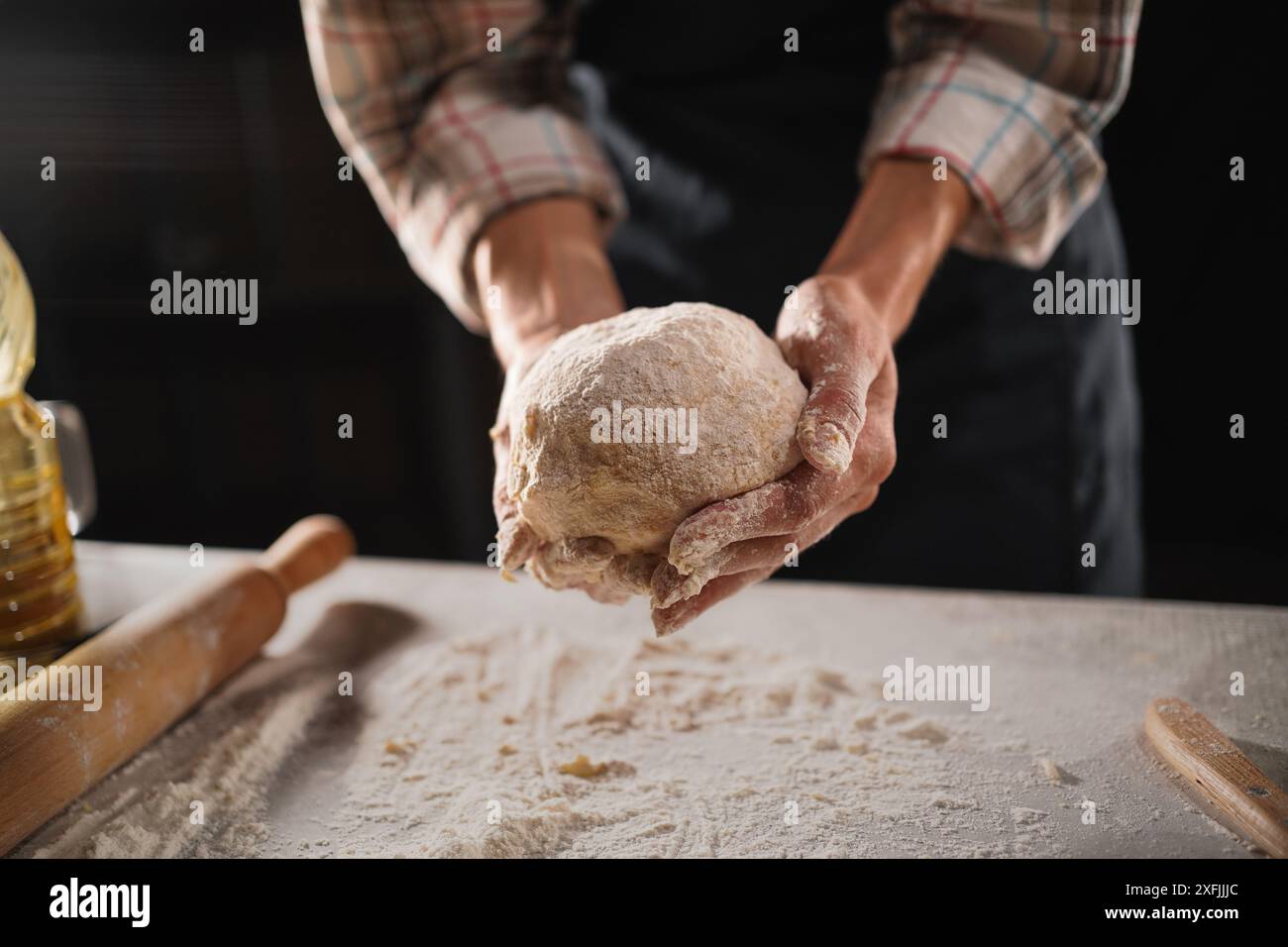Woman hands holding dough above table before putting into the Oven ...