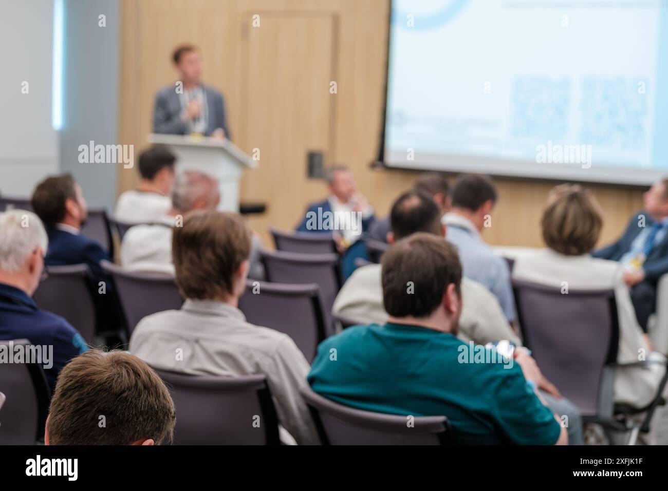 Group of business professionals attending a tech conference, listening ...