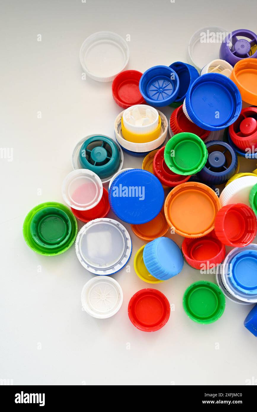 Photo with a Multi-colored caps from plastic bottles lie on the table ...