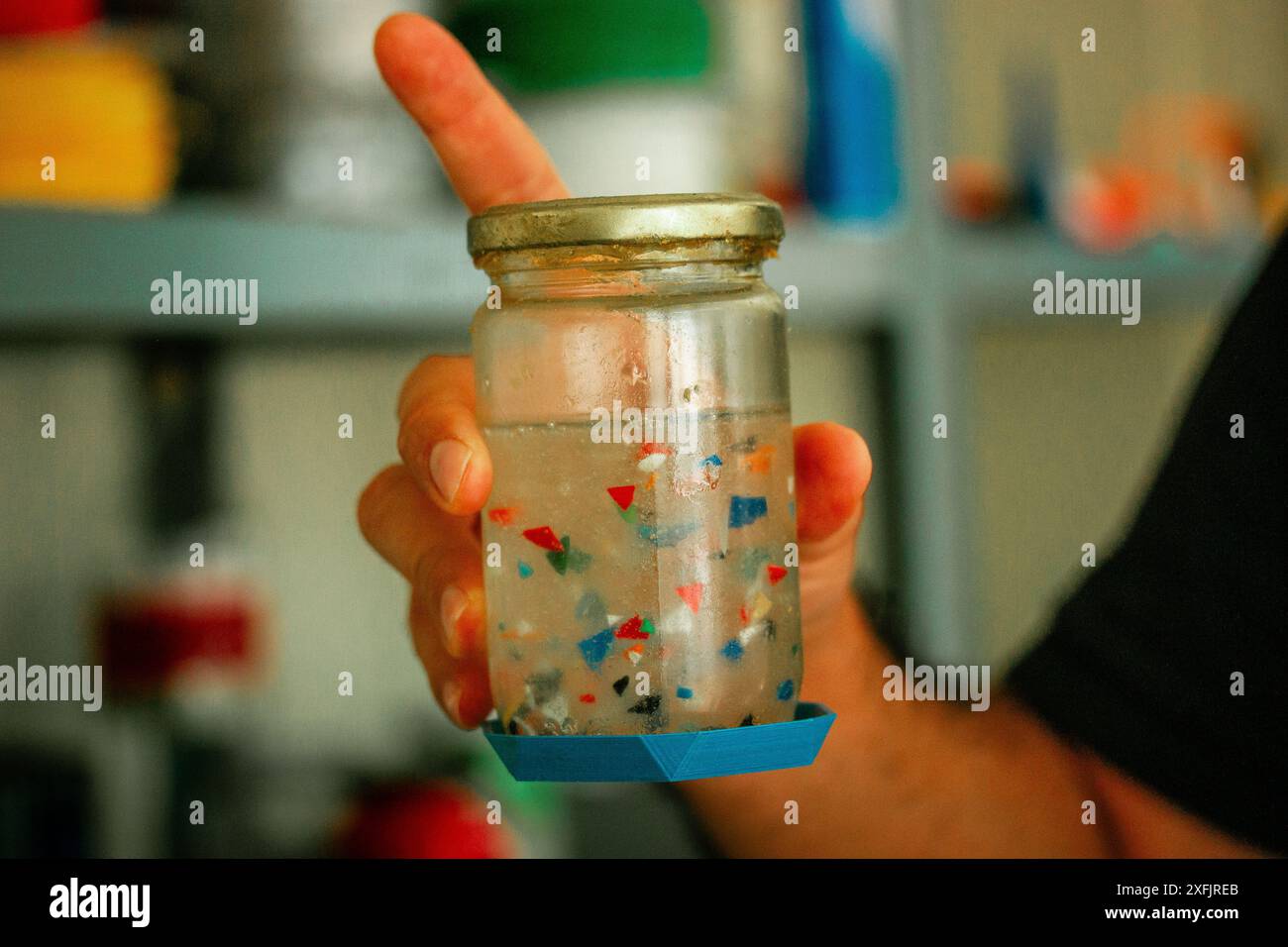 Colorful plastic parts floating inside of a bottle in a hand ...
