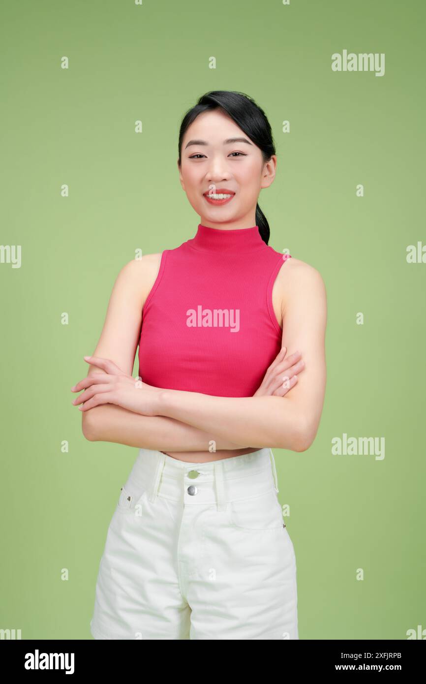 A confident woman poses against a green background, embodying summer ...