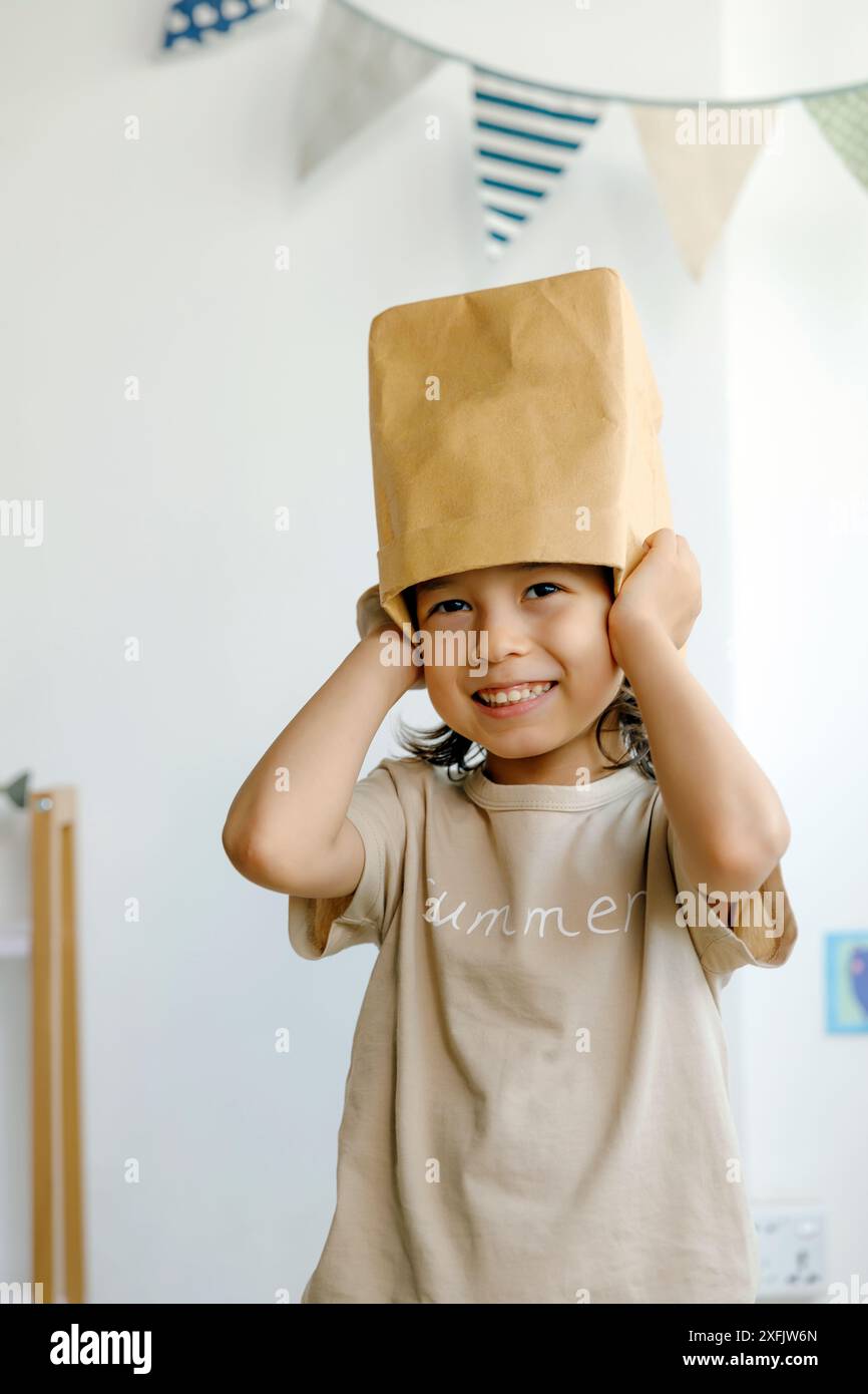 Playful Little Boy Wearing a Paper Bag Hat in a Colorful Indoor Space ...
