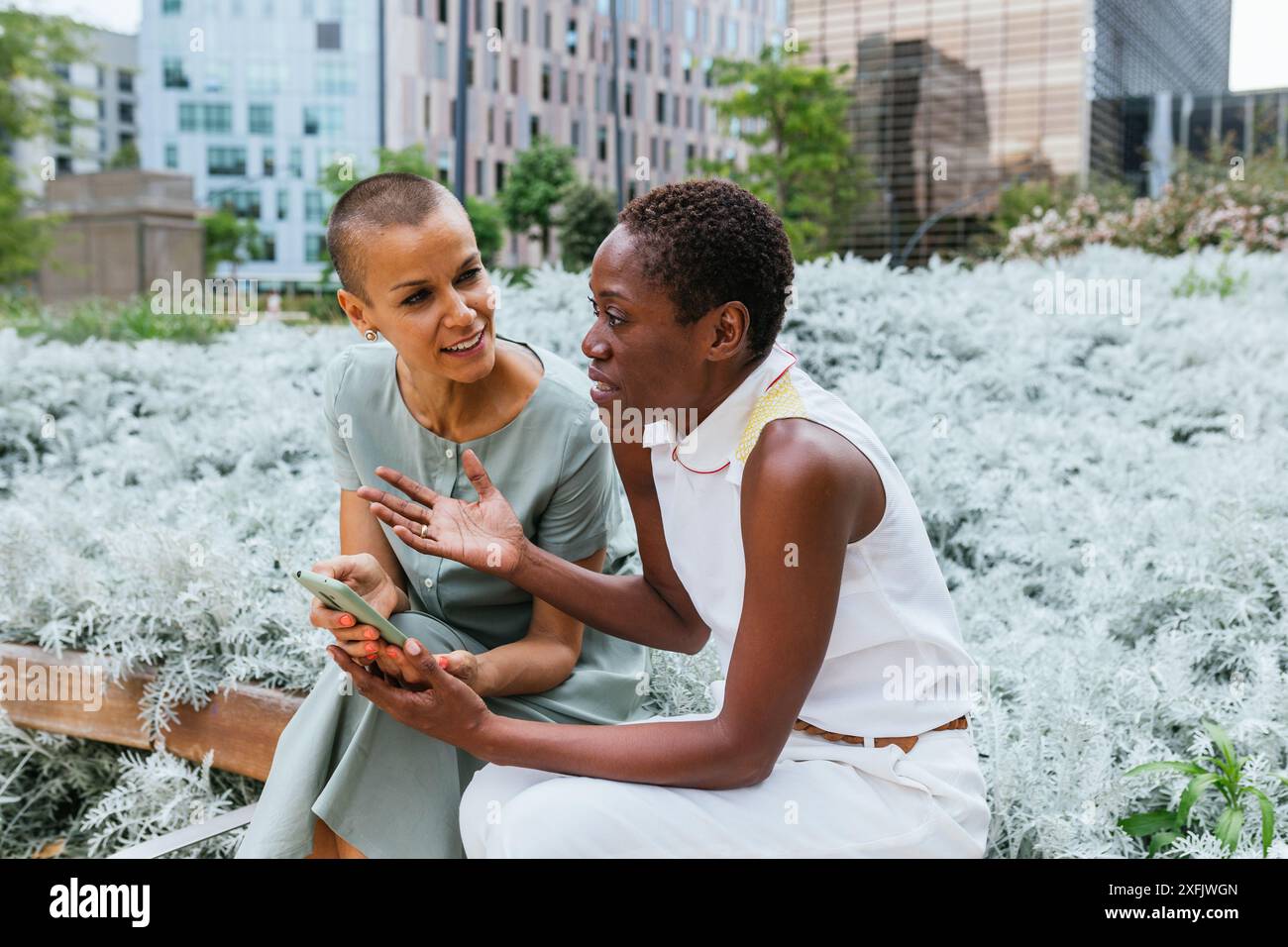 Two professional women engaged in a serious conversation with ...