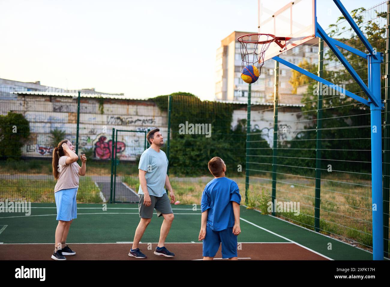 Motion shot of Happy father and kids playing basketball together ...