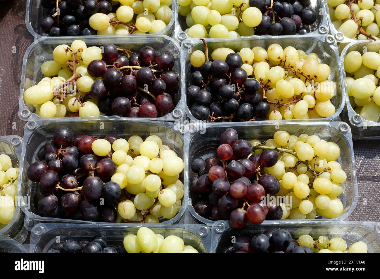 Dark and green grapes in bowls on a market stall, top view, Germany ...