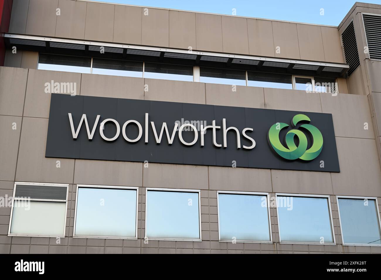 Large elevated Woolworths supermarket sign on the side of a building ...