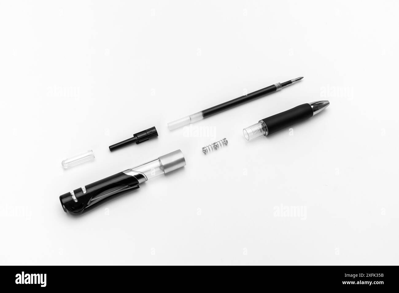 Disassembled gel automatic pen with a black gel rod on a white ...