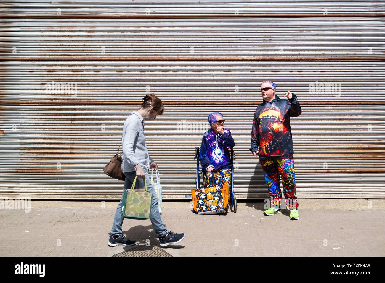 Two people wearing brightly coloured garish clothes in Newquay Town ...