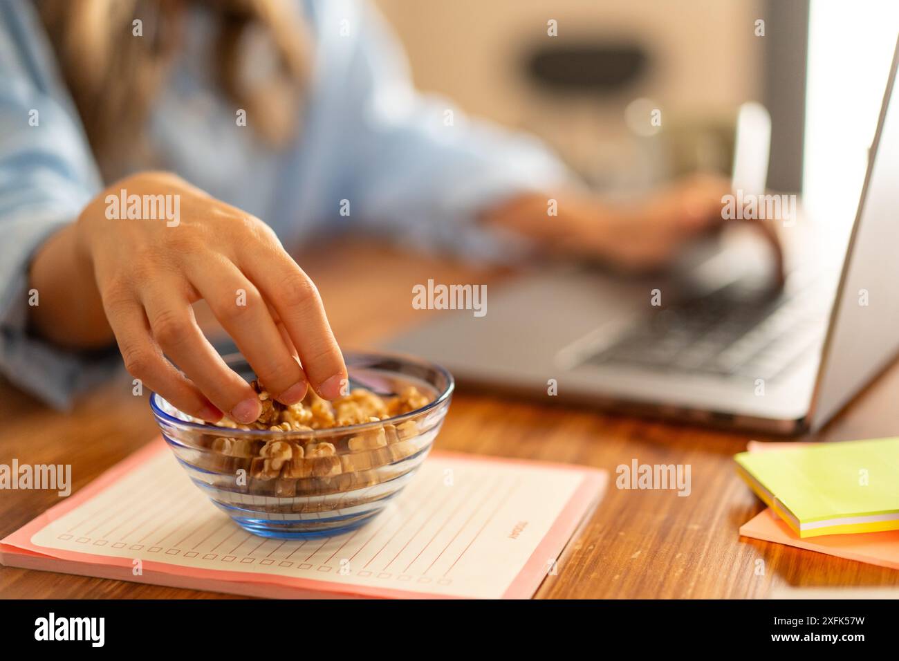 Healthy snack at work - hand reaching for nuts on desk, office setup ...