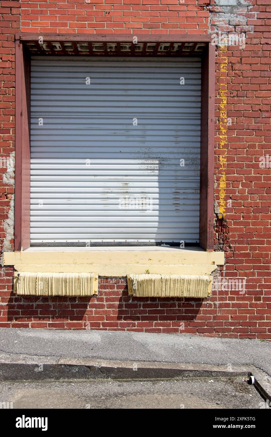 Loading dock with damaged brick to the side Stock Photo - Alamy