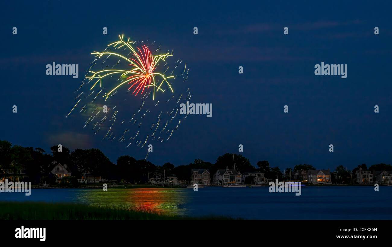NORWALK, CT, USA - JULY 3, 2024: A red and green firework explodes over ...