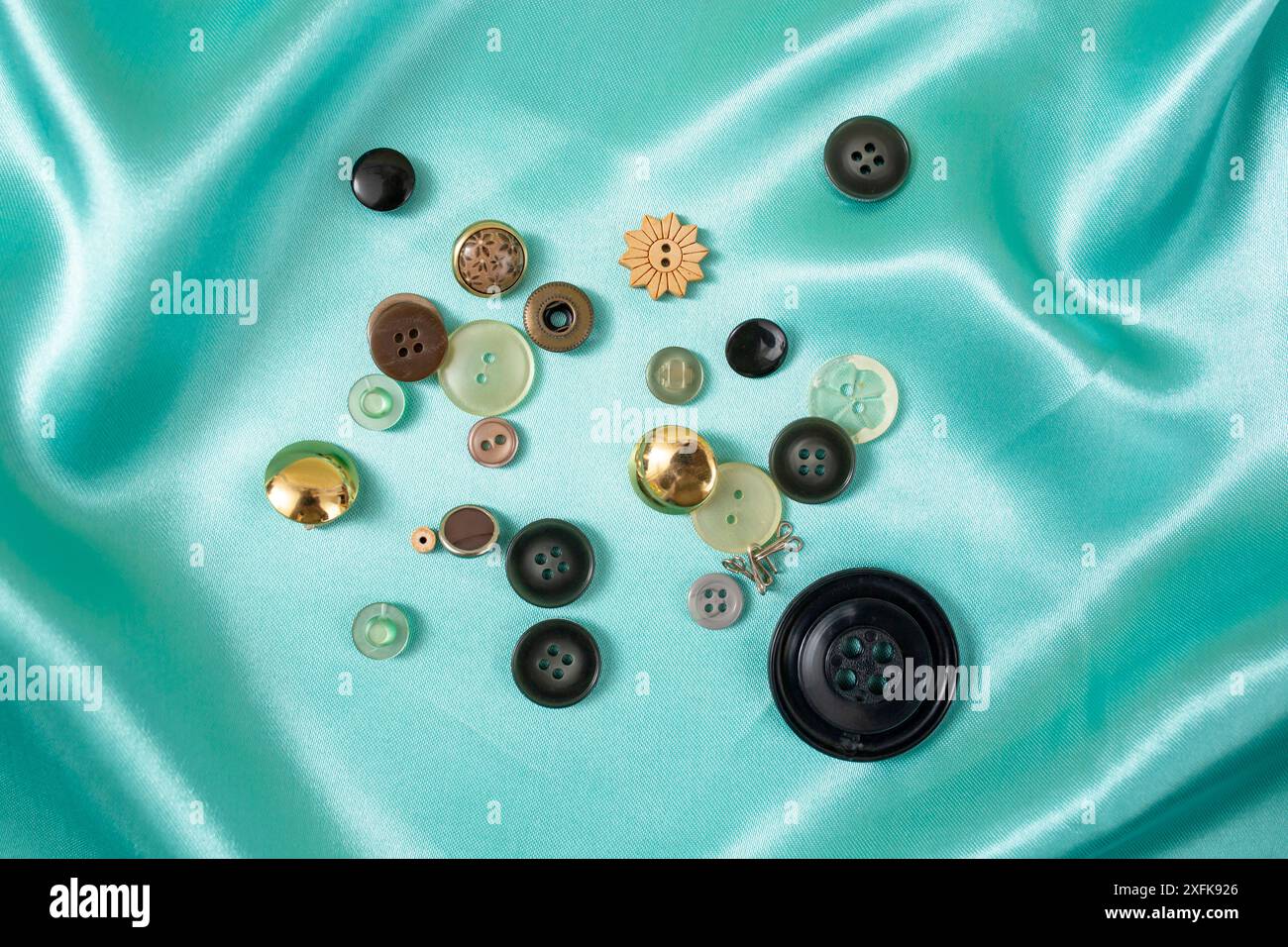 Different size and color buttons on turquoise satin fabric Stock Photo ...