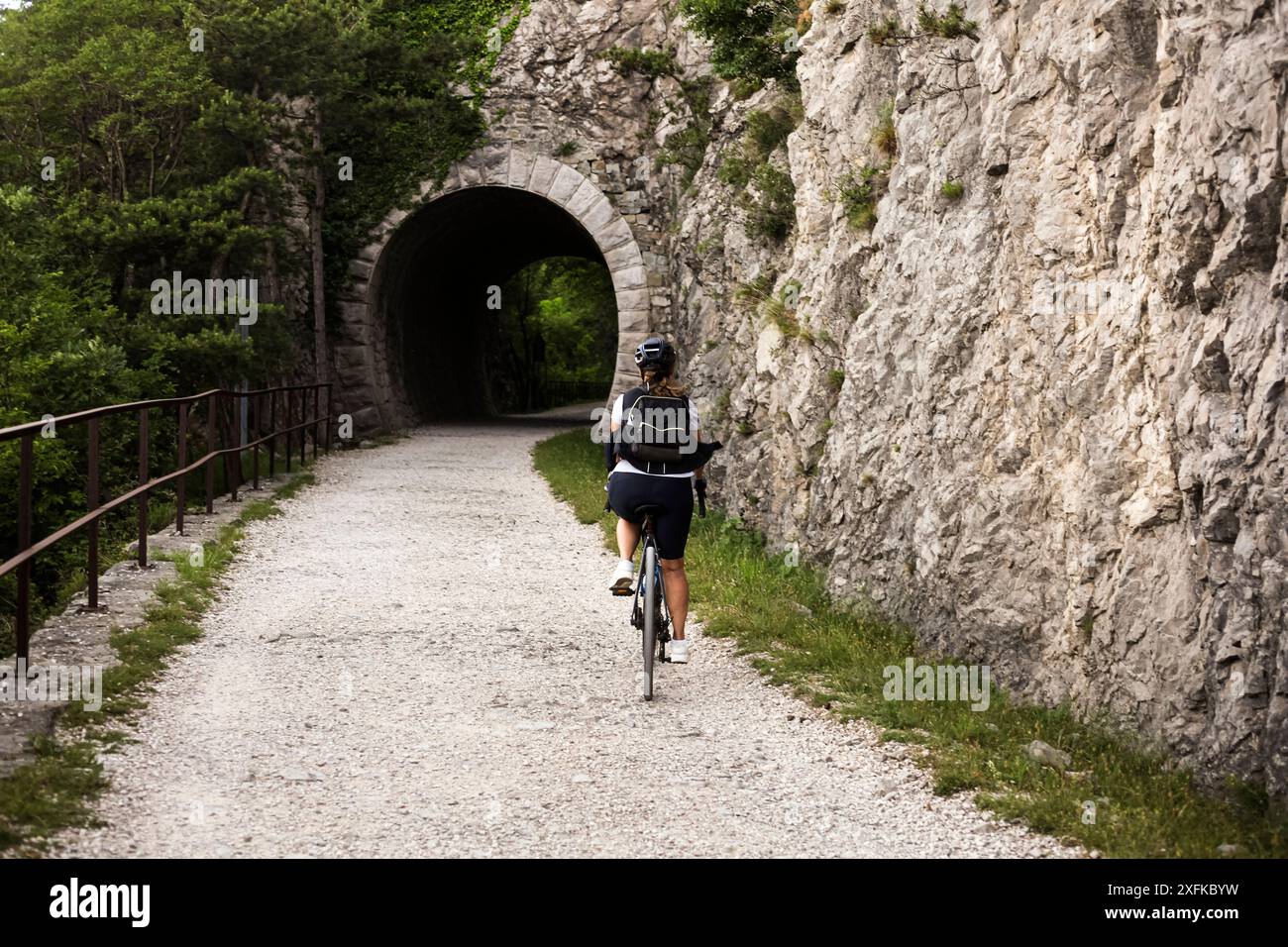 Mountain biking young woman riding on bike in the old railway ...