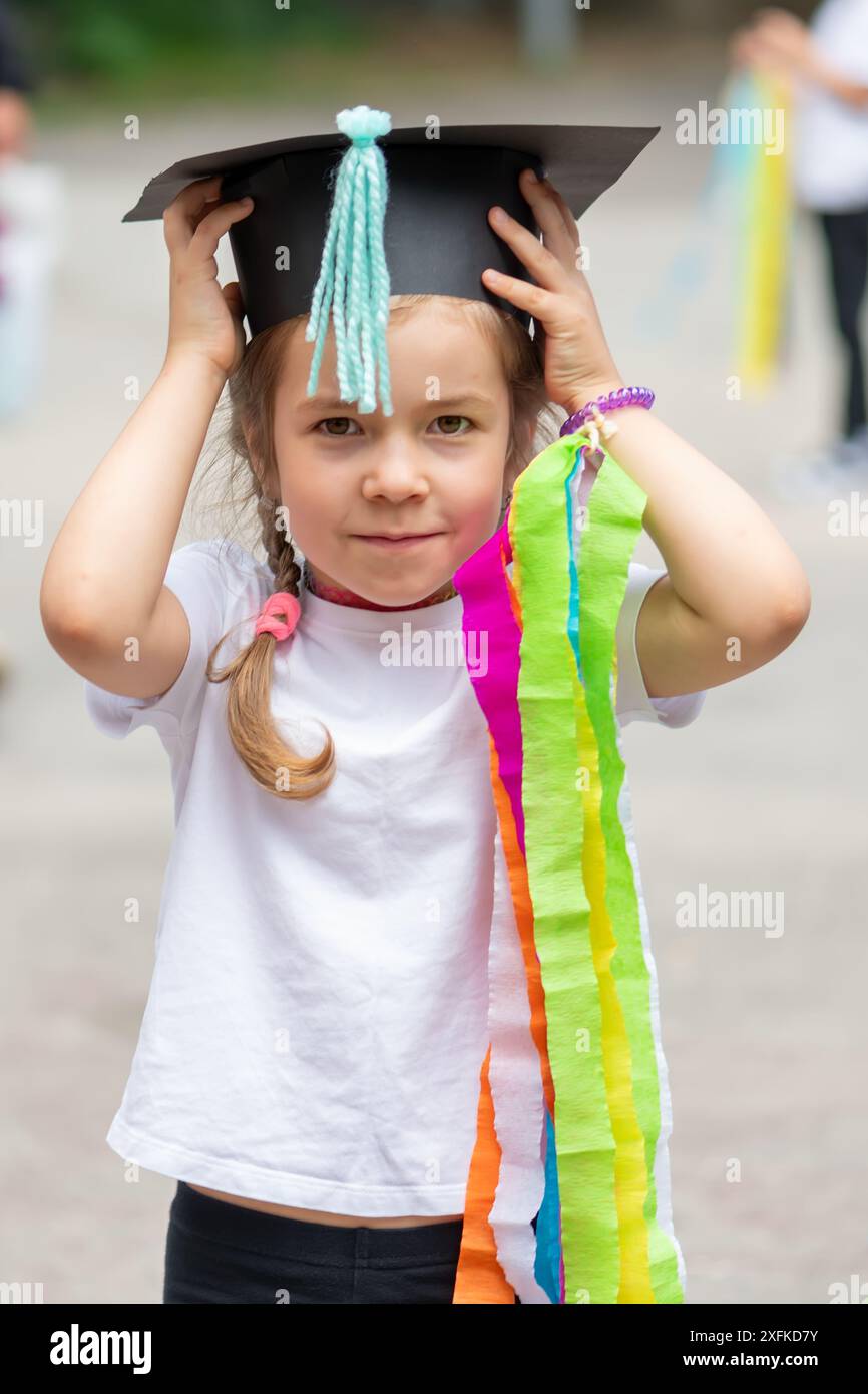 Girl in graduation cap with multicoloured ribbons on her arm. Concept ...
