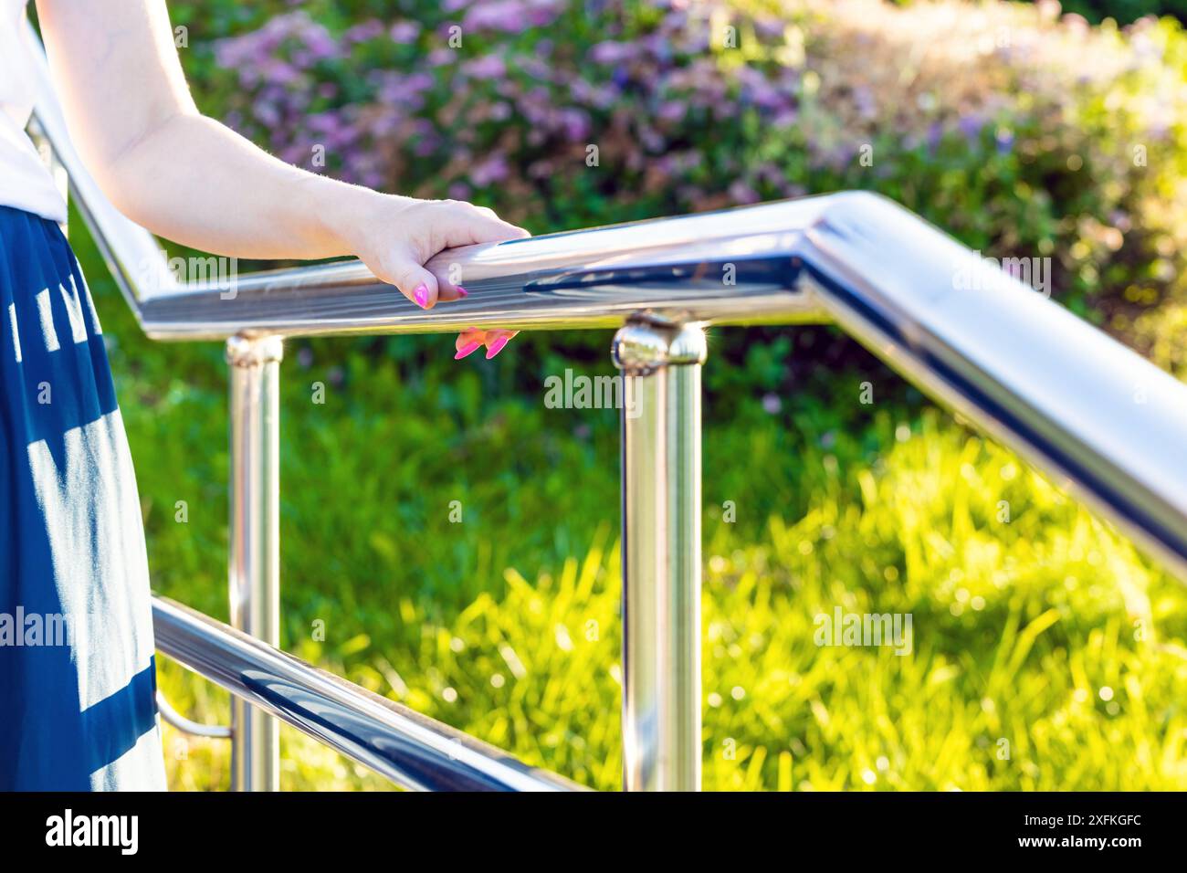 woman's hand holding onto the metal staircase railing. a man goes down ...