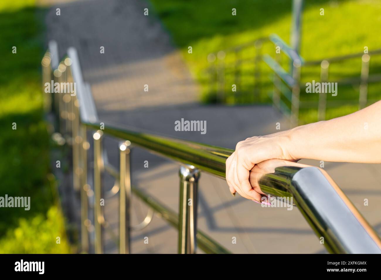 woman's hand holding onto the metal staircase railing. a man goes down ...