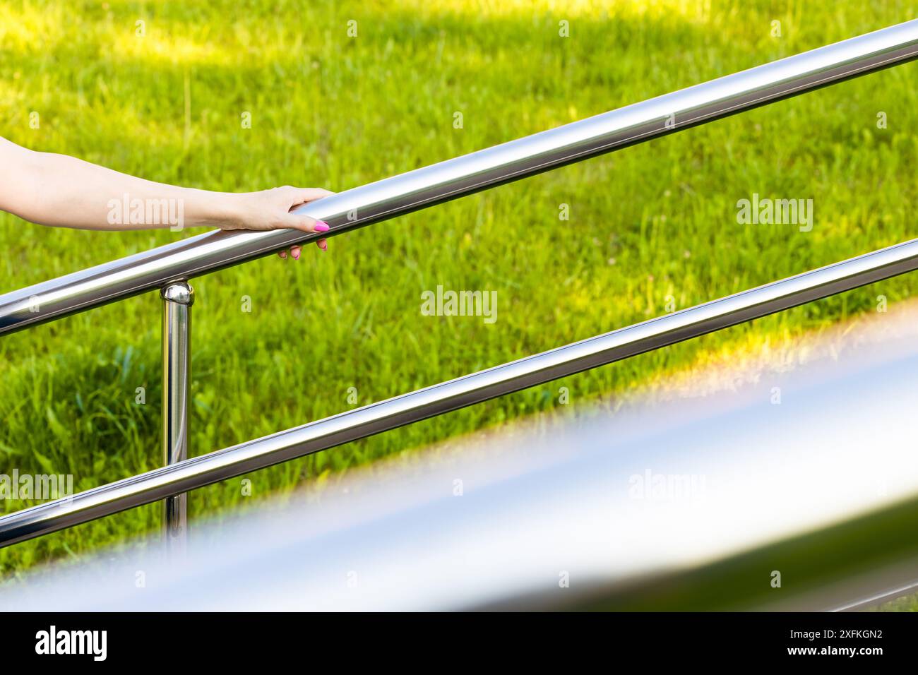 woman's hand holding onto the metal staircase railing. metal stair ...