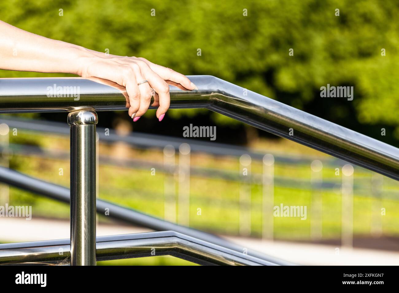 woman's hand holding onto the metal staircase railing. a man goes down ...