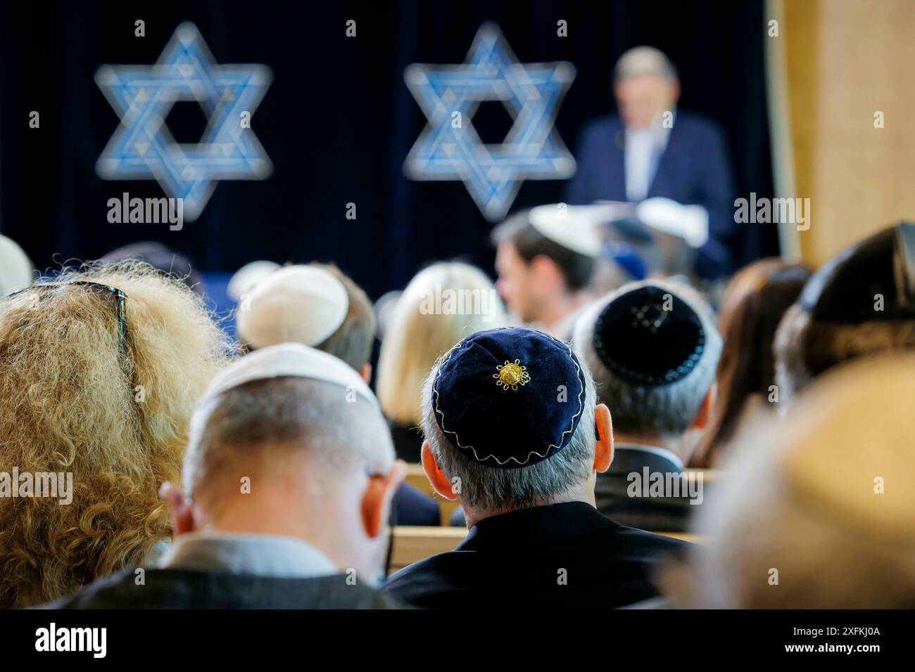 Men wearing kippahs sit in the synagogue during the inauguration of the ...