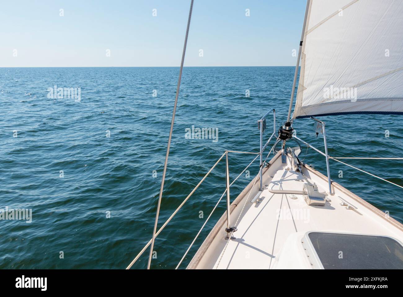 White yacht sailing on a sunny summer day. Top down view from the deck ...