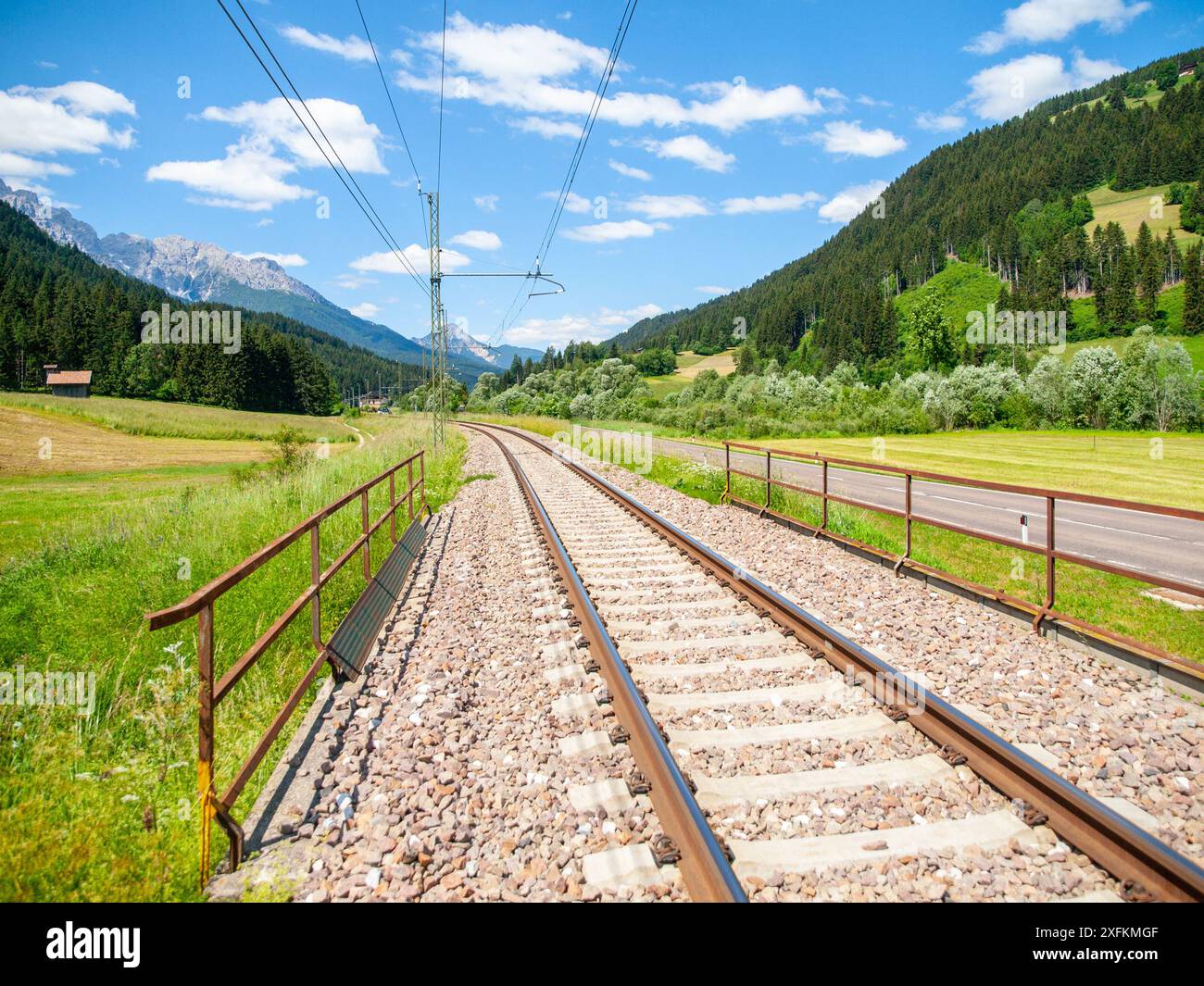 In the Dolomites, Italy, a set of train tracks runs through a scenic ...