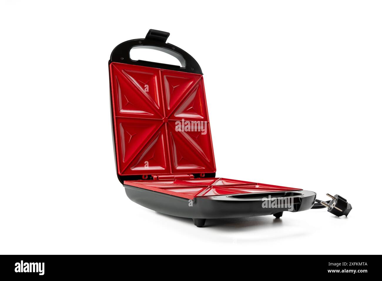 A red and black electric sandwich maker stands on a white background ...