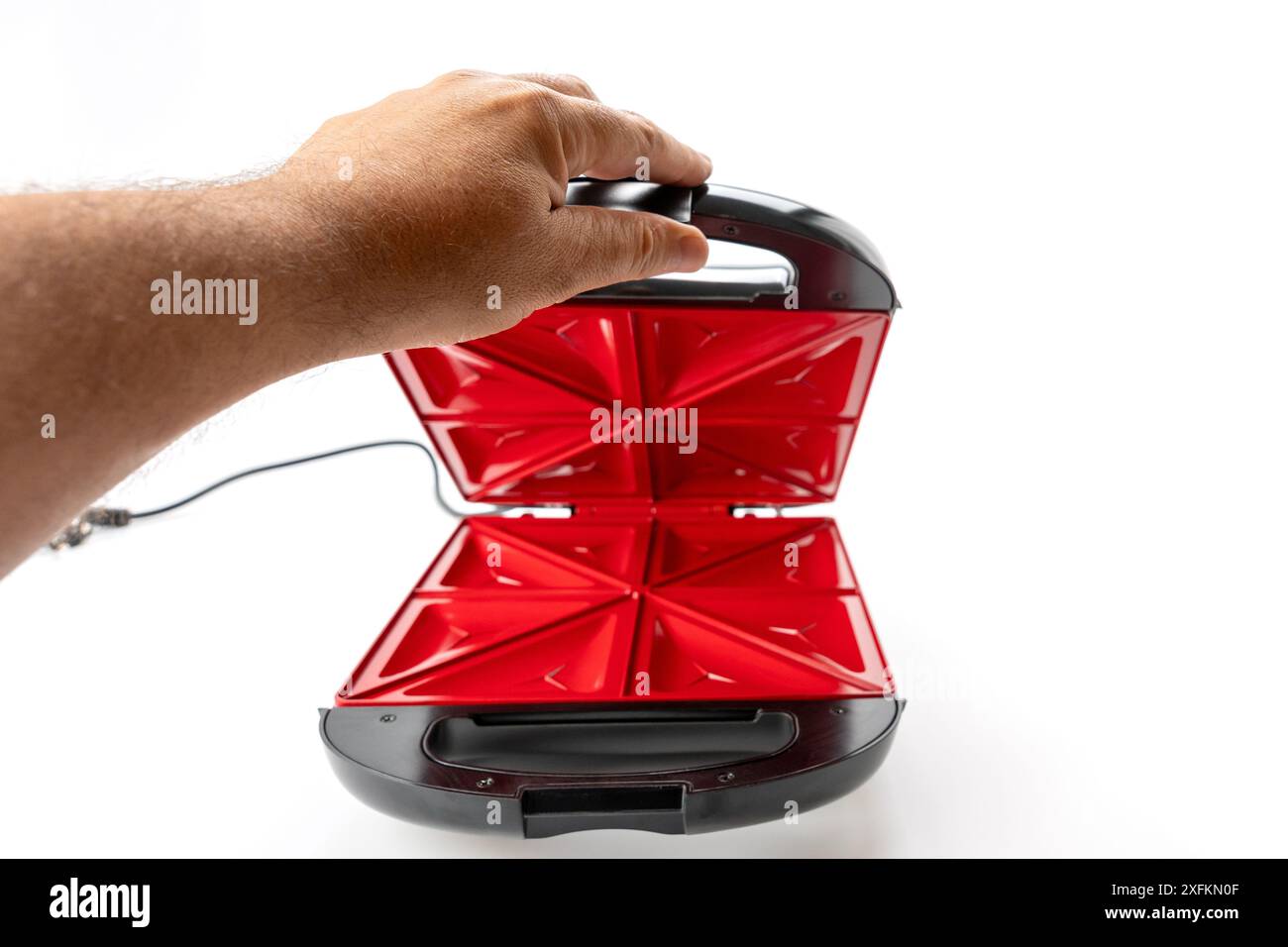 A person is holding a red and black toaster oven. The toaster oven is ...